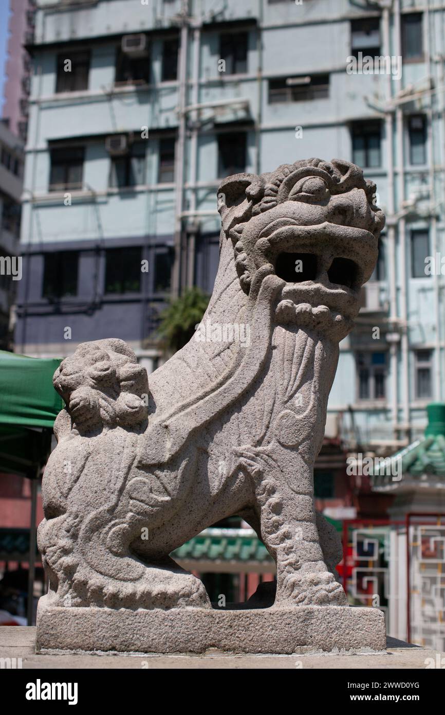 The sculpture of a Chinese guardian lion with a long tongue hanging ...