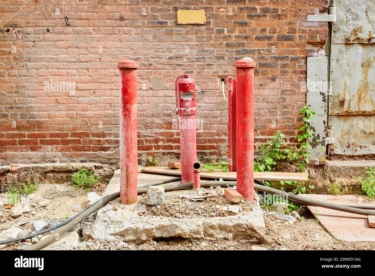 Red Pipes and Pump Rising from Concrete Pad Stock Photo - Alamy