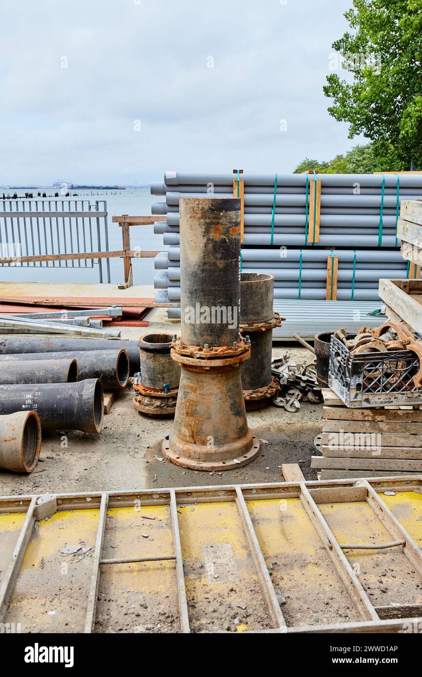 Large Iron Pipe on End next to Stack of PVC Tubes Stock Photo - Alamy