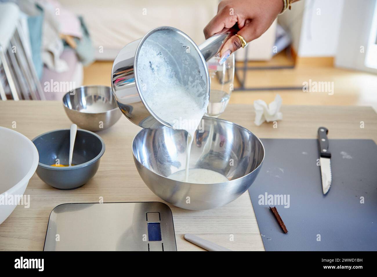 Black Hand Pouring Cream Mixture into a Bowl Stock Photo - Alamy