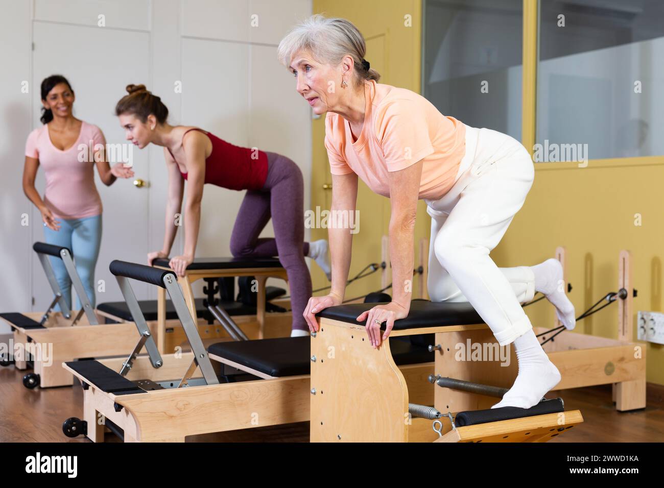 Elderly woman doing exercises on wunda chair in pilates studio Stock ...