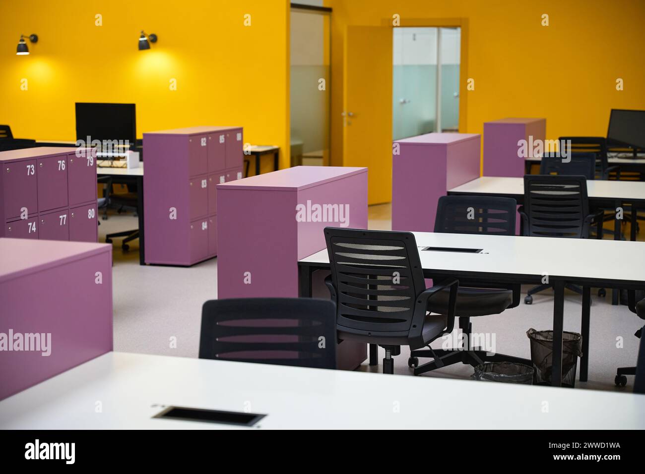 Call center with yellow walls and tables standing in lines Stock Photo ...