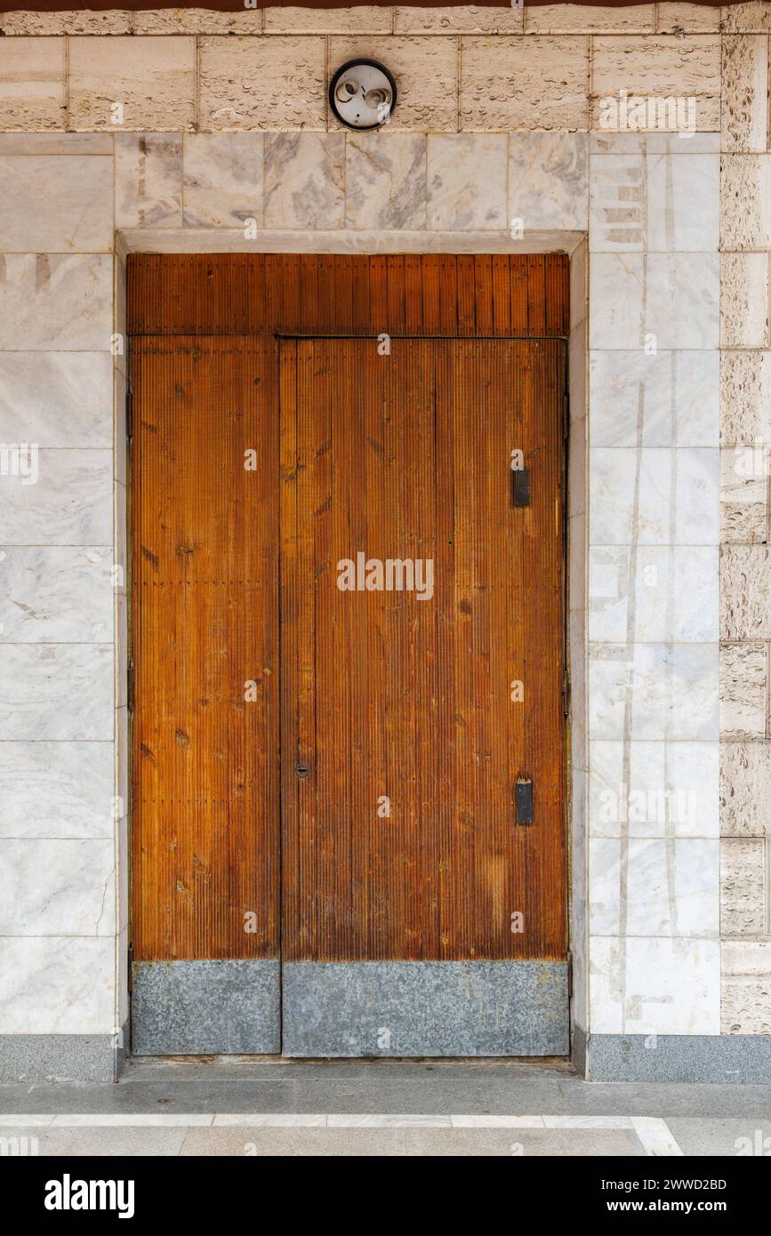old wooden door of soviet public building in a wall made of shell rock ...