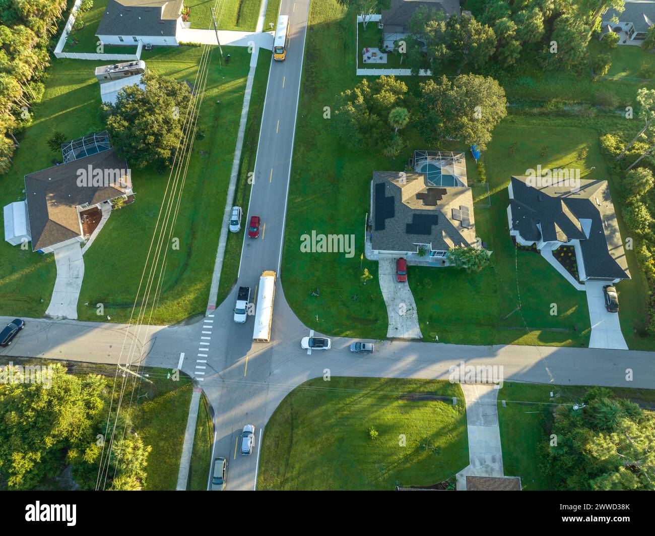 Aerial view of american yellow school bus driving on suburban street ...