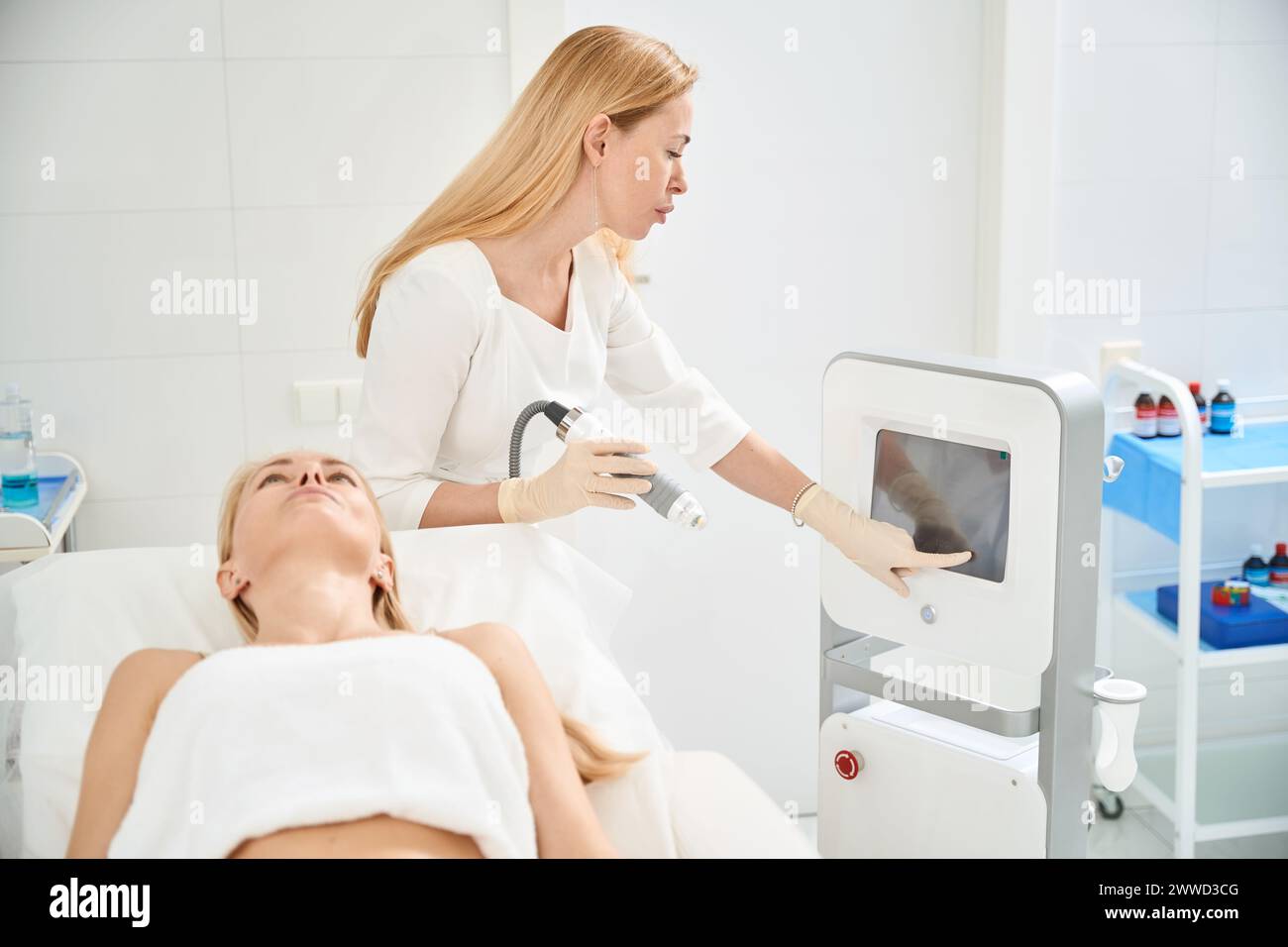 Woman worker of aesthetic medicine clinic adjusting microneedle rf ...