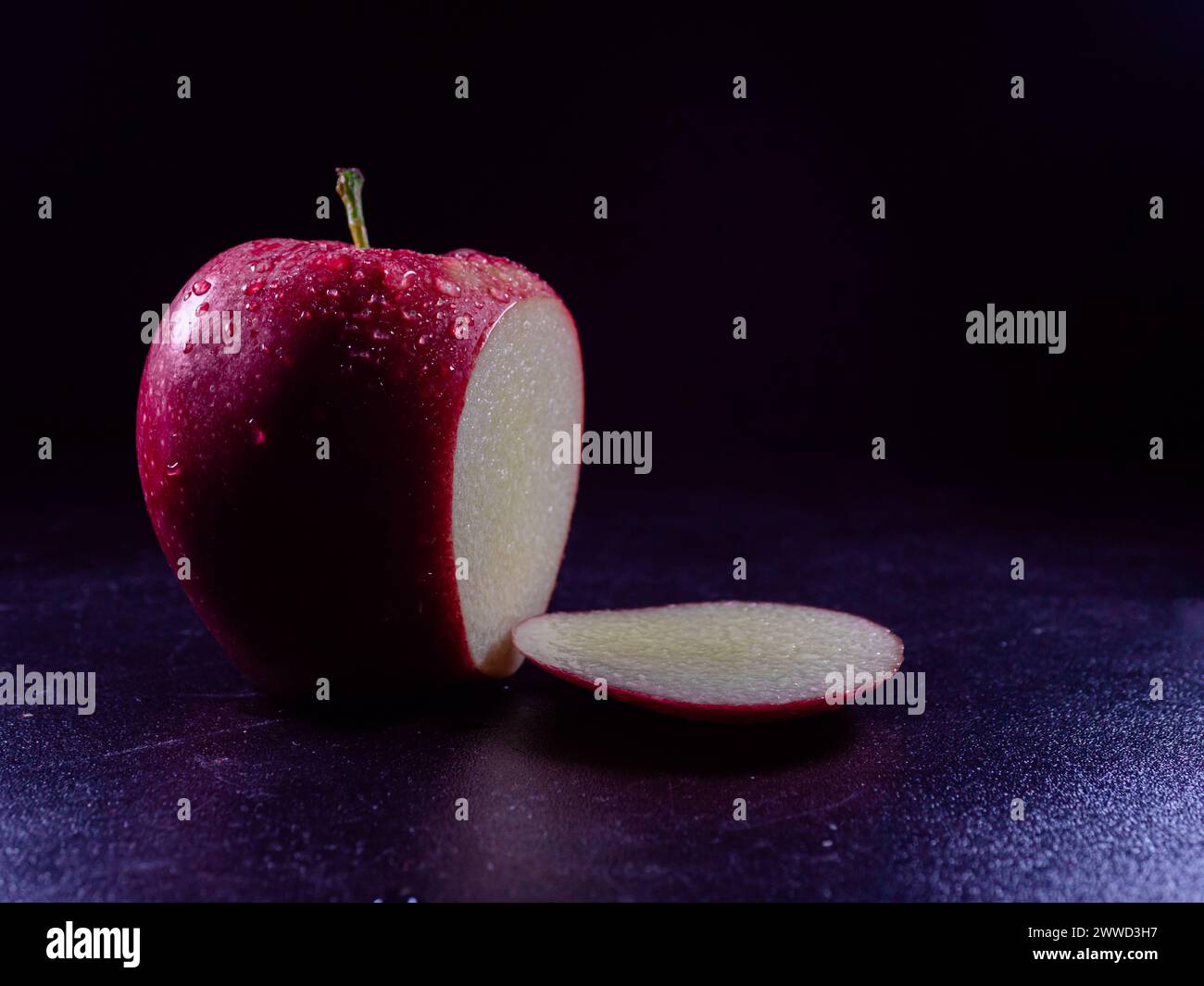 A delicious fresh and crisp red apple with water drops. Black ...