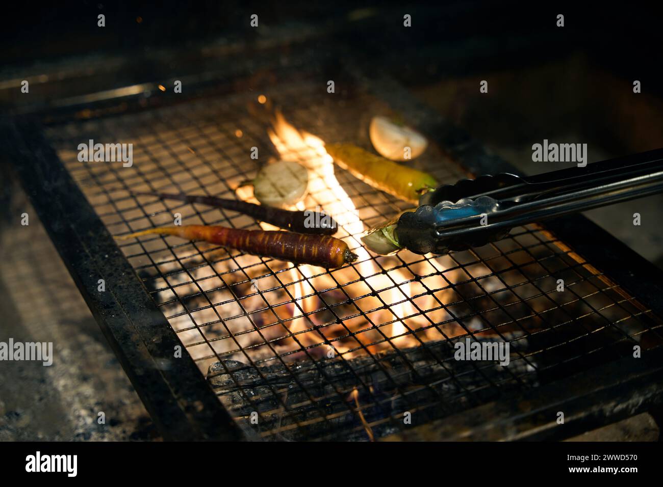 Vegetables frying on iron net in burning fire place in restaurant Stock ...