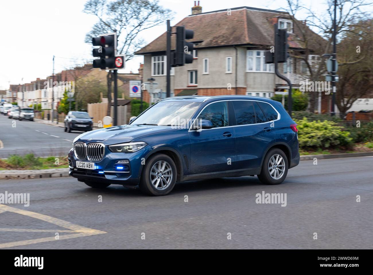 Unmarked police car with flashing blue lights driving at speed on ...