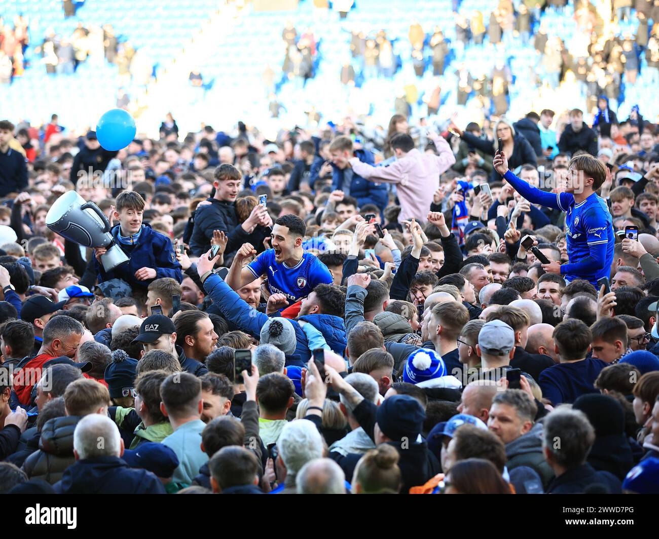 Chesterfield players and fans celebrate winning the League on the pitch ...