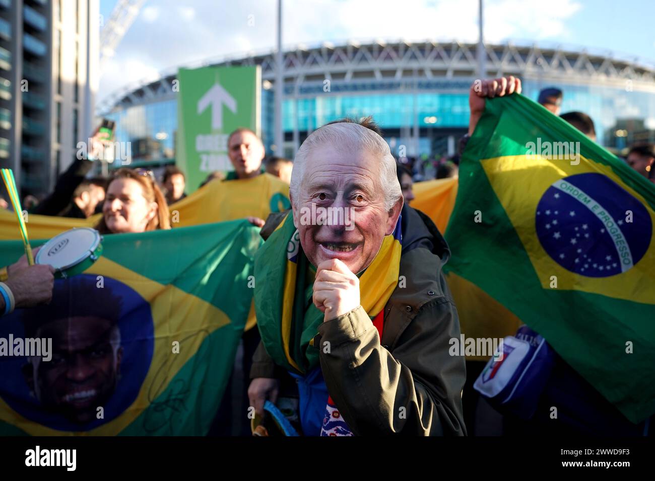 Brazil fans holding a King Charles III face mask on Wembley Way ahead ...