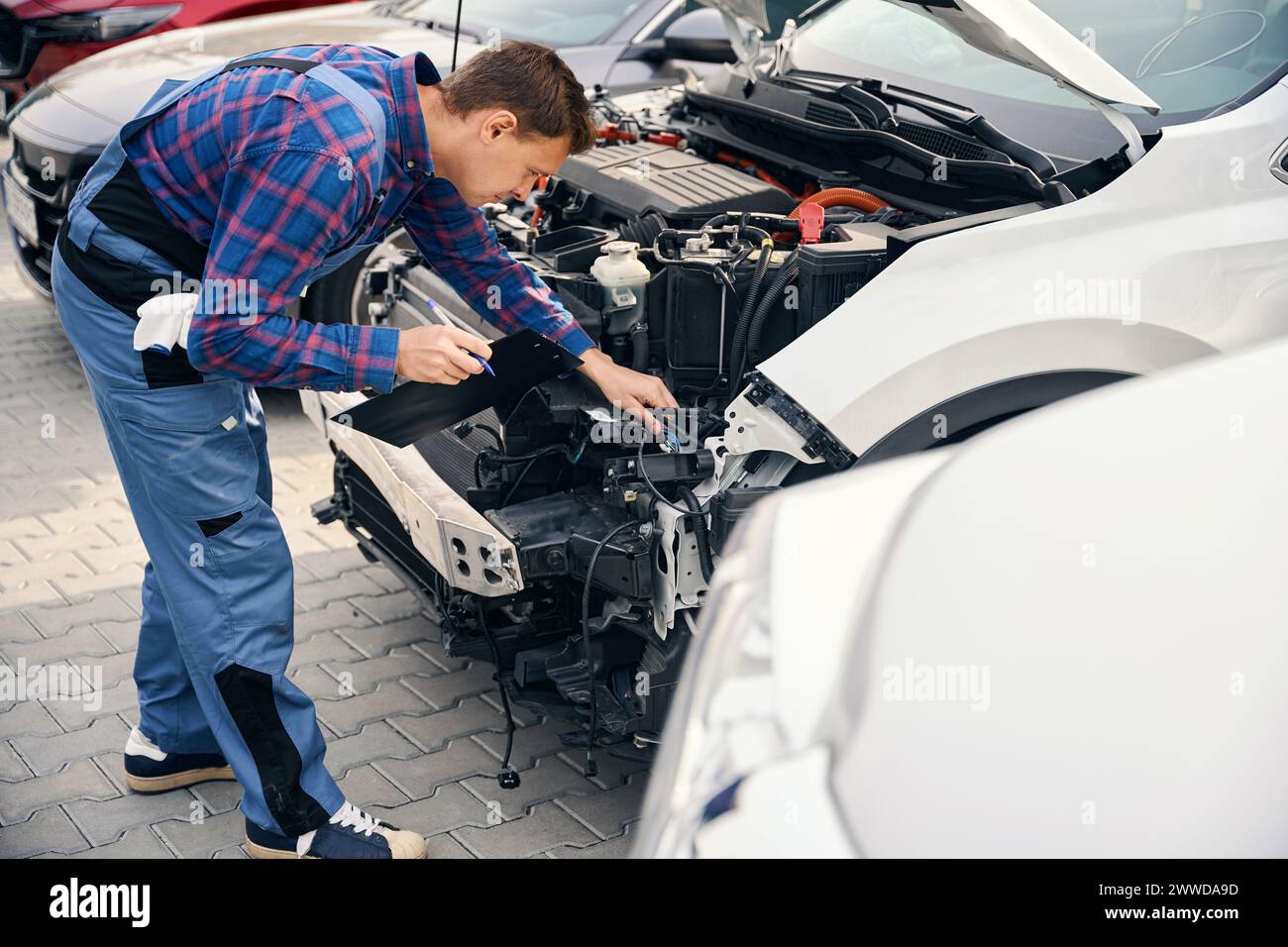 Male on vehicle examination, identification of broken parts Stock Photo ...