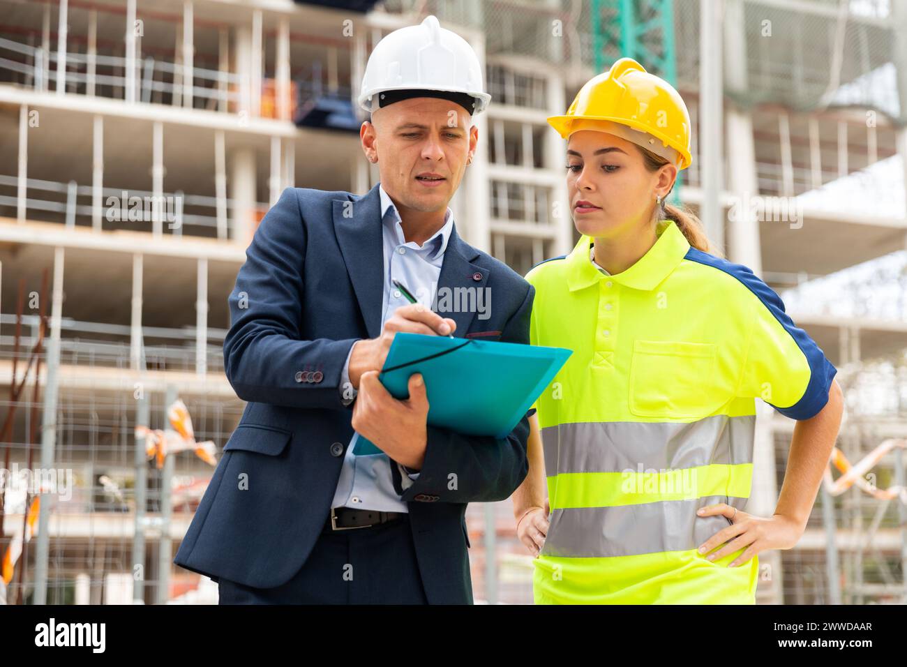 Two builders planning their work in construction plant Stock Photo - Alamy