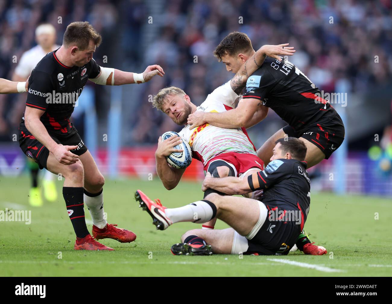 Harlequins' Tyrone Green (centre) is tackled by Saracens' Alex Goode ...
