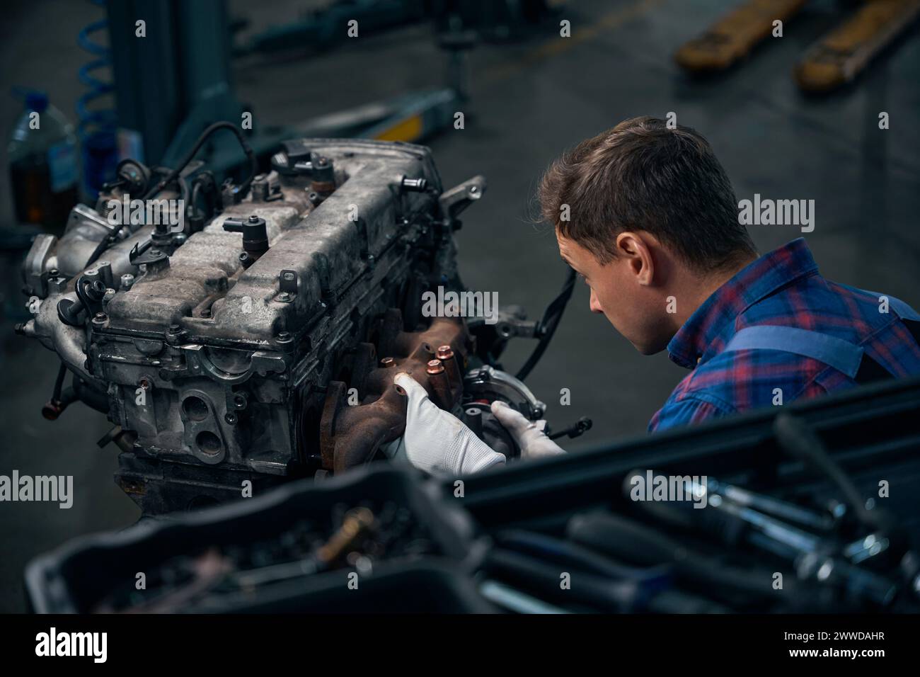 Man installing exhaust manifold on machine engine Stock Photo - Alamy