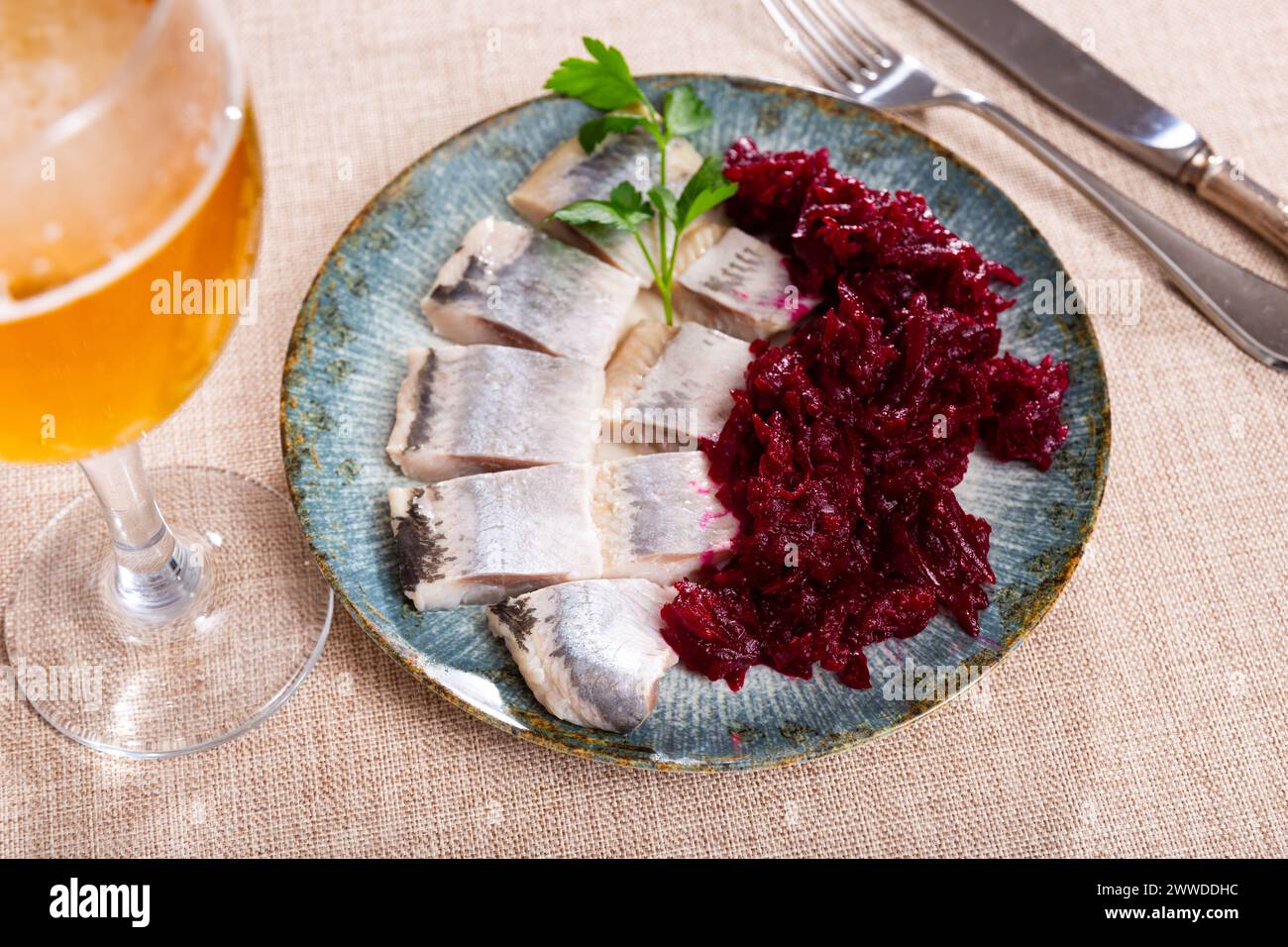 On round blue plate - lightly salted herring fillet cut into pieces ...