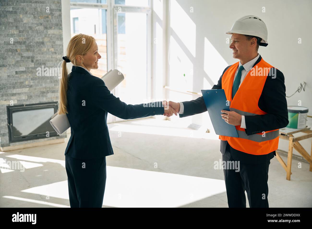 Woman and foreman standing in room and shaking hands Stock Photo - Alamy