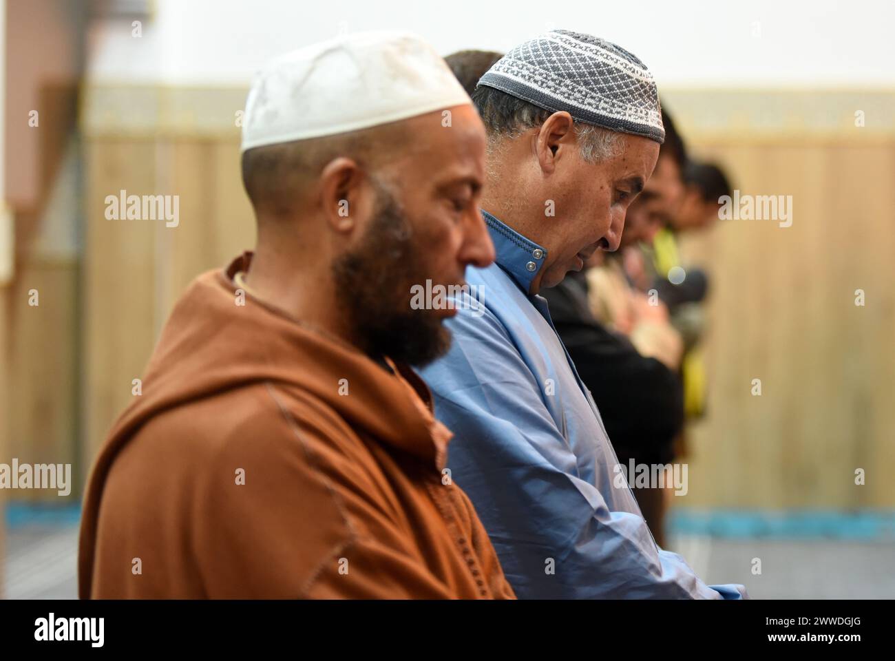 Several Muslim men pray standing with their arms crossed during the ...