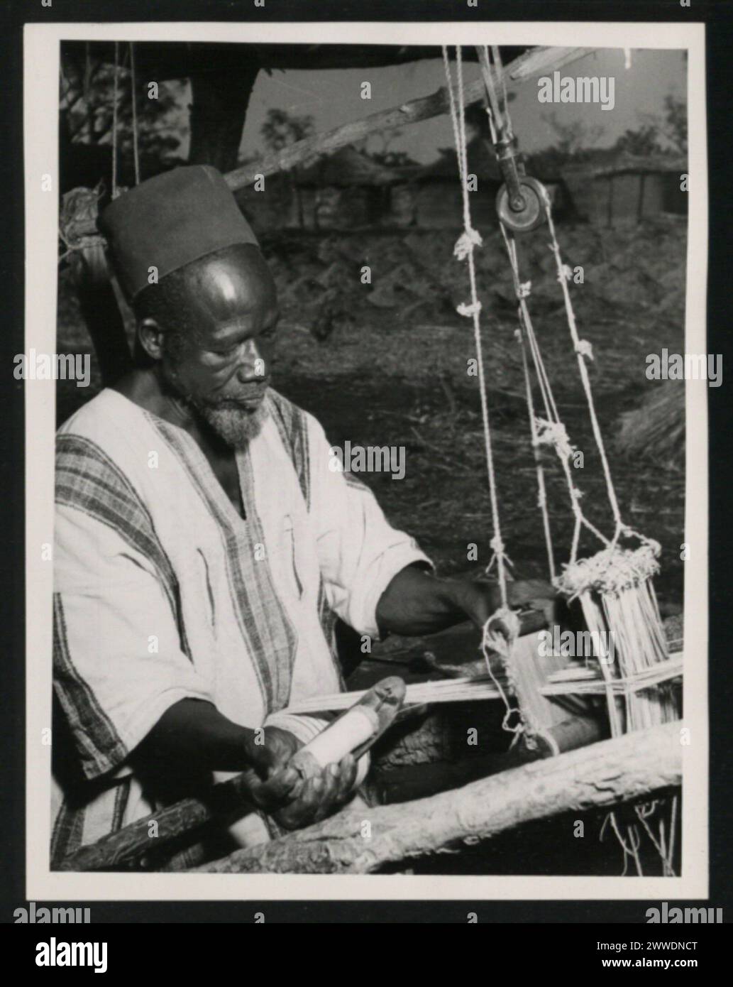 Photograph of a weaver practicing his craft at Flyboyiri, Ghana. The ...