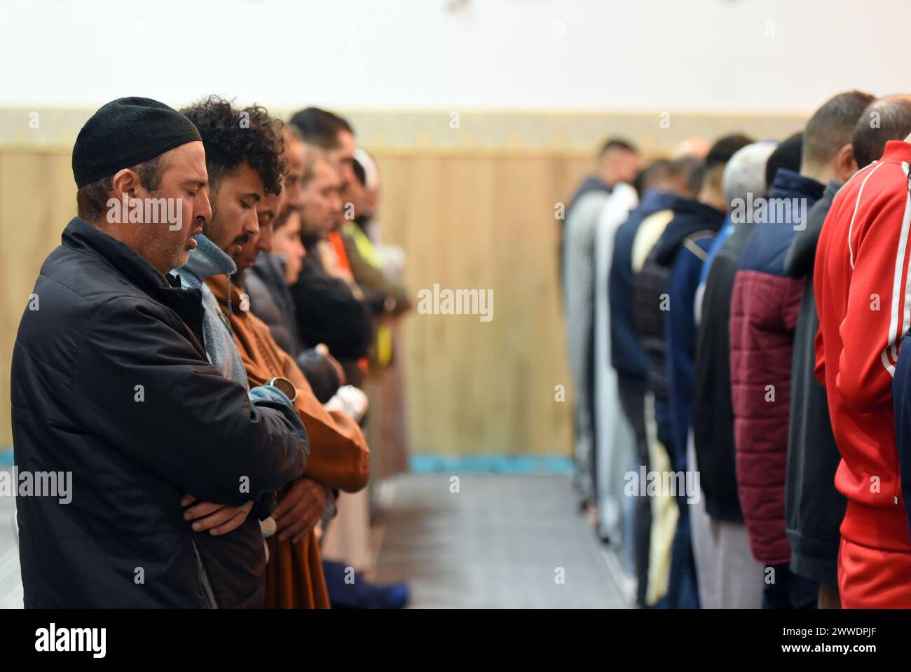 Several Muslim men pray standing with their arms crossed during the ...