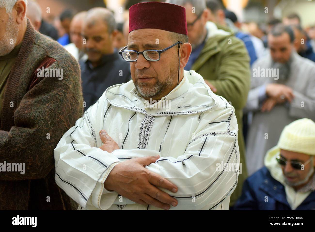 A Muslim man prays standing with his arms crossed during the fifth ...