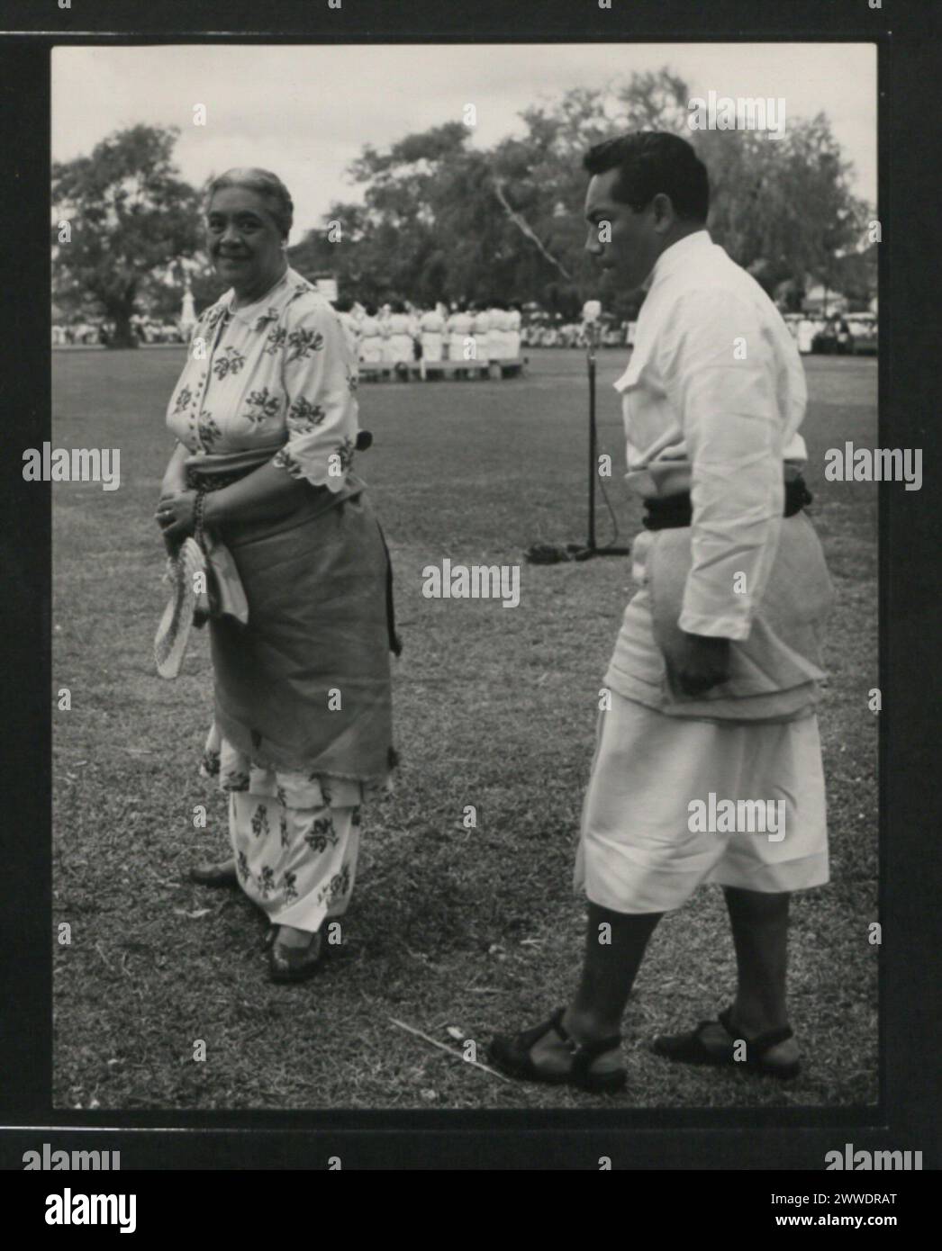 Queen Salote of Tonga arrives at a park accompanied by her aide ...