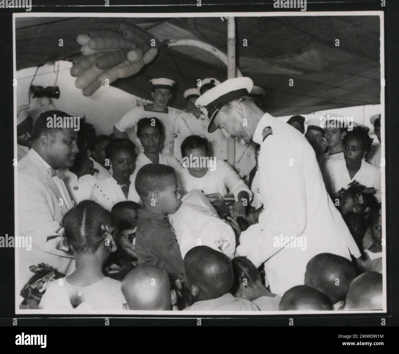 Description: Captain R.H. Connell receiving the wood carving of a ...