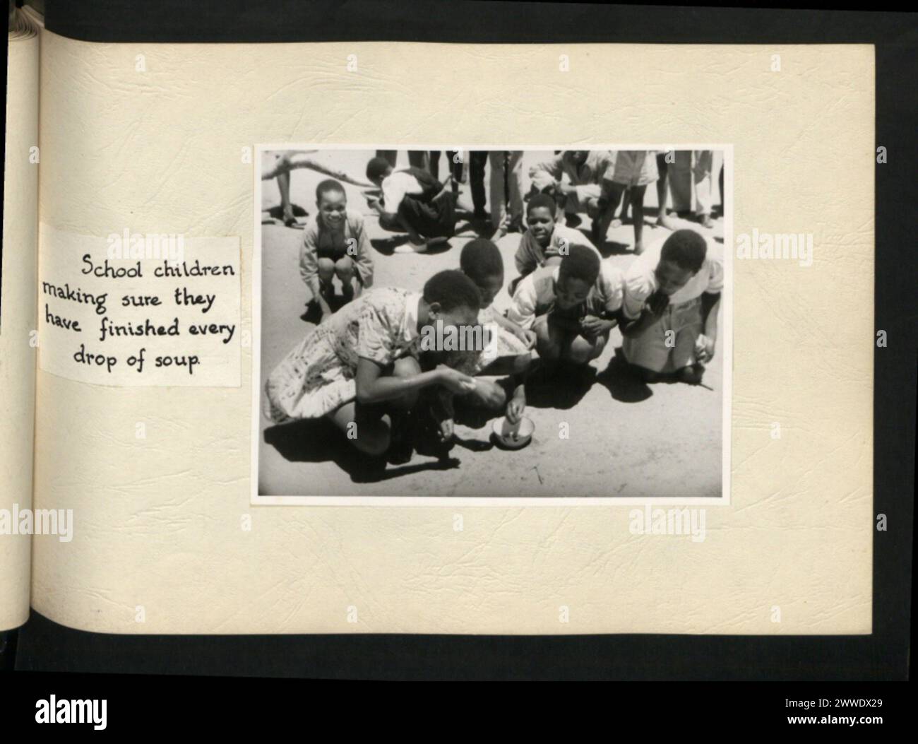 Description: School children making sure they have finished every drop ...