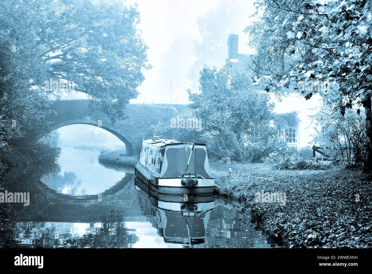 Atmospheric black & white image of a moored narrowboat near an arched ...