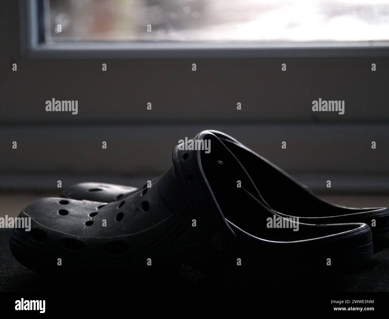 Rubber clogs on a door mat with light coming from a window Stock Photo ...