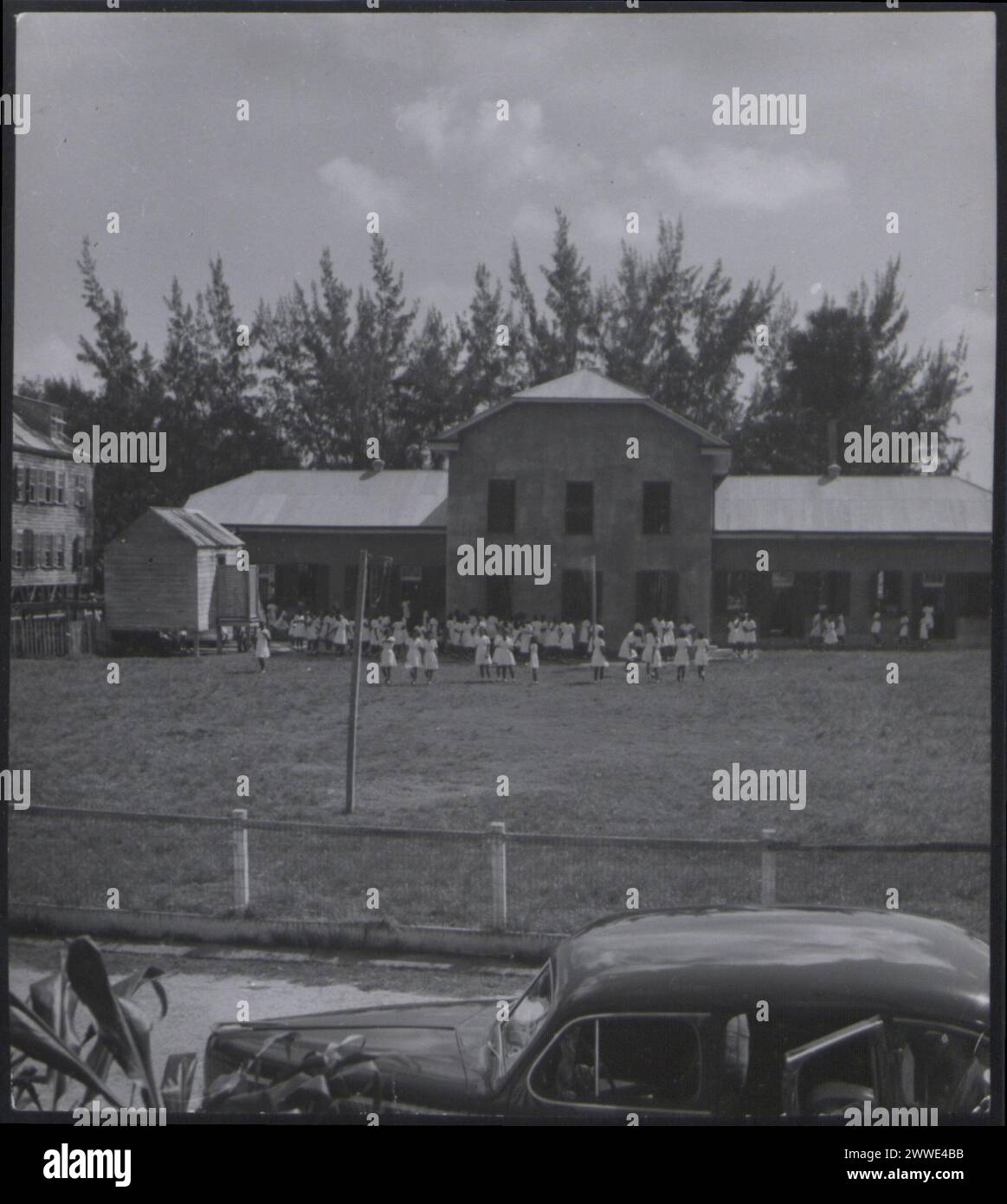 Exterior view of a school in Belize shows pupils outside in 1948 ...