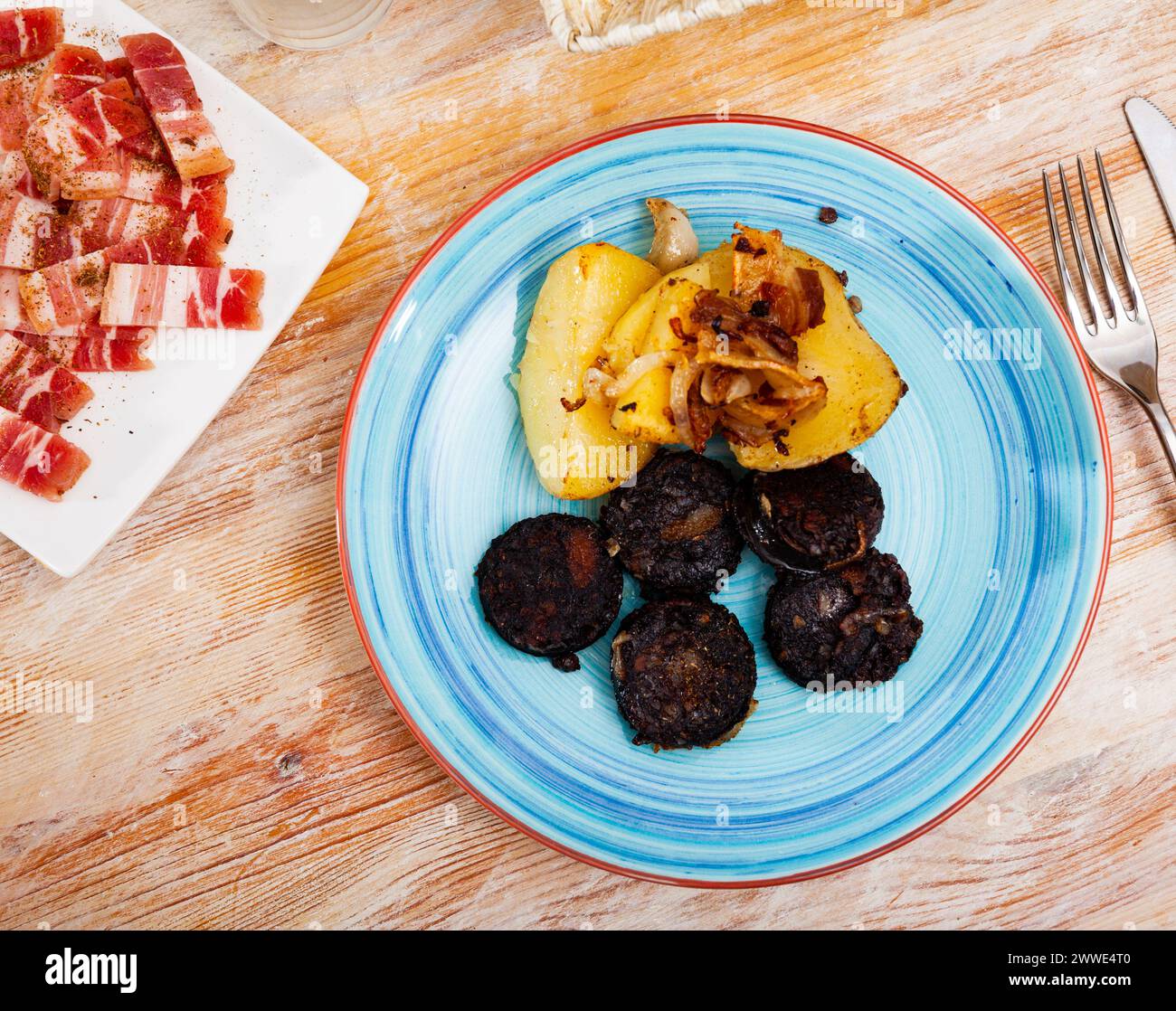Fried blood sausage morcilla served with baked potatoes Stock Photo - Alamy