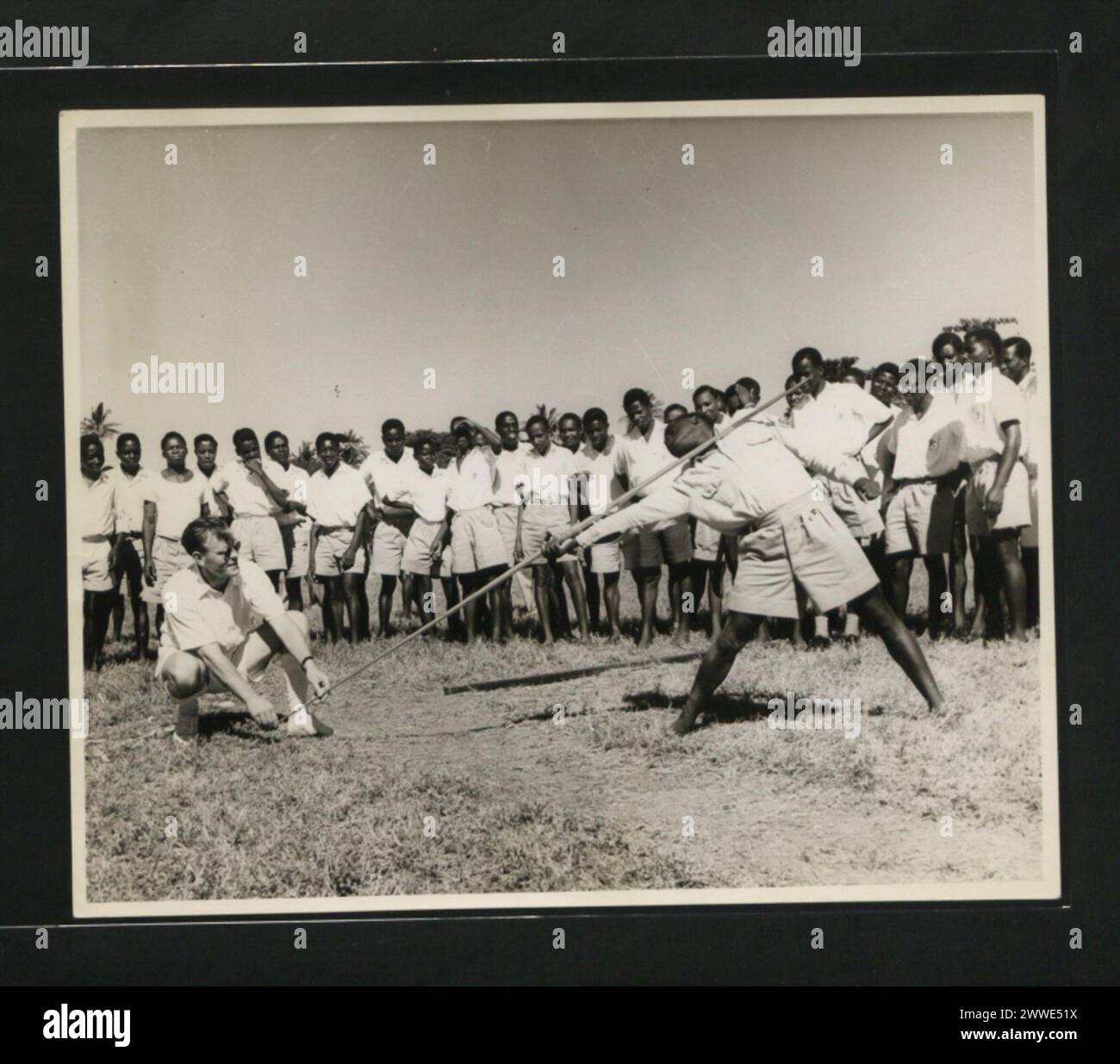 Description: A Sports Officer coaching an African in the correct way to ...