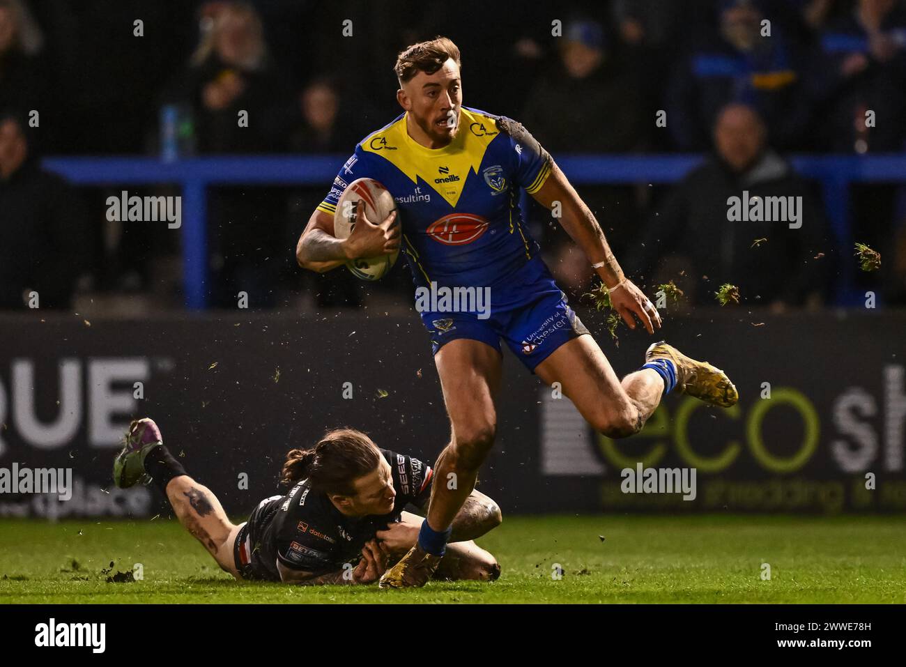 Matty Ashton of Warrington Wolves breaks the tackle of Jarred Bassett ...