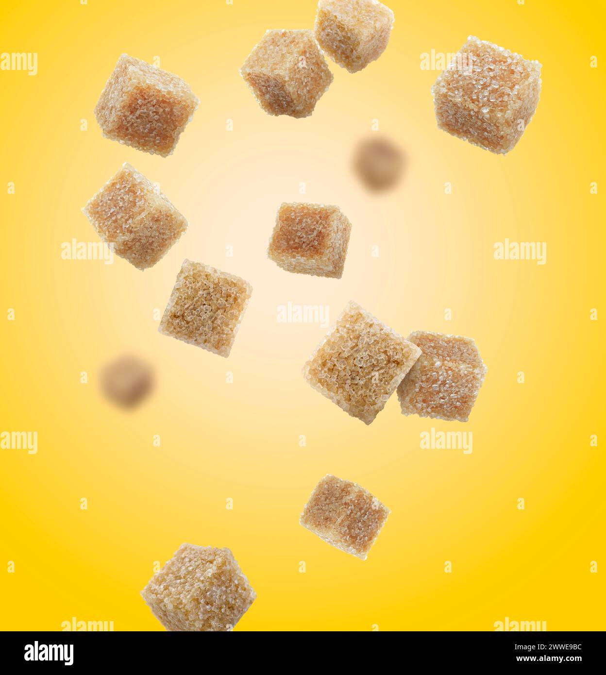 Brown cane sugar cubes falling on golden gradient background Stock ...