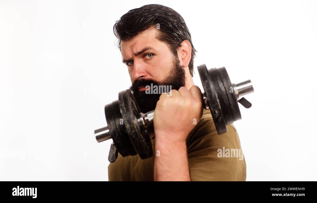 Serious man with dumbbell in hands. Bearded sportsman lifting dumbbell in sport club. Strong ...