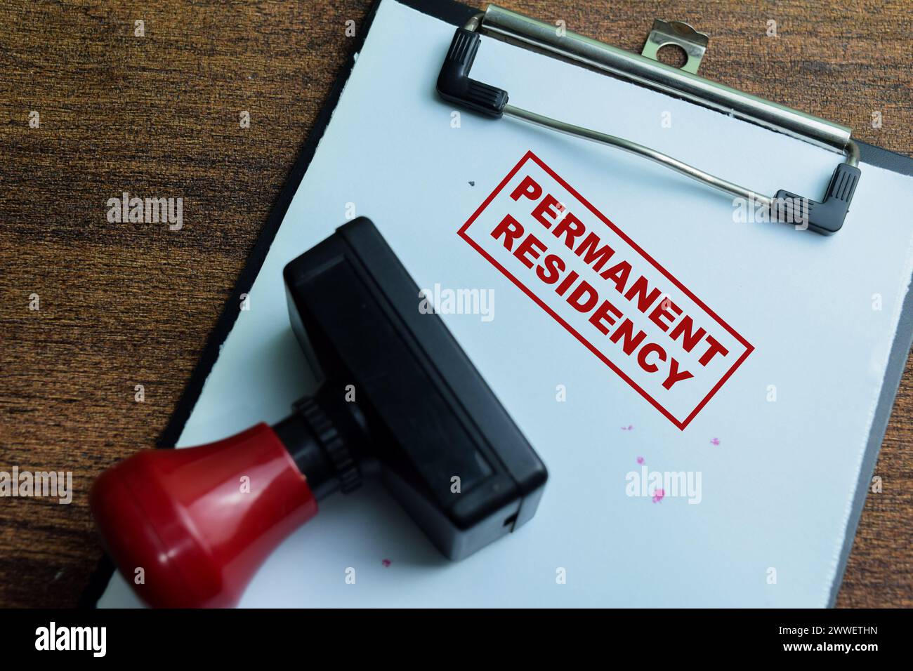Red Handle Rubber Stamper and Permanent Residency text above book ...