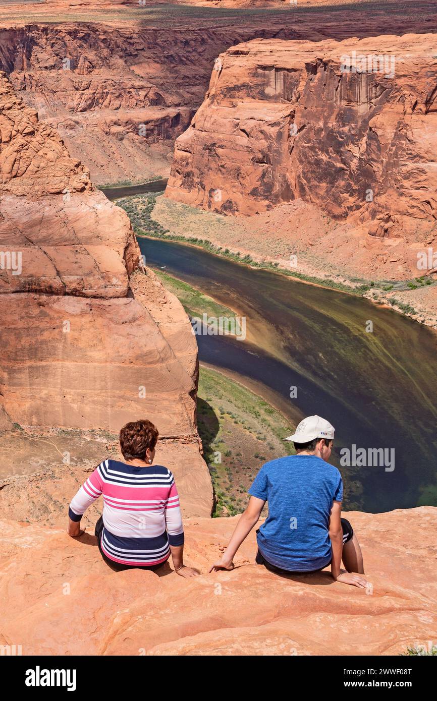 Tourists sitting near the world famous Horseshoe Bend, Glen Canyon ...