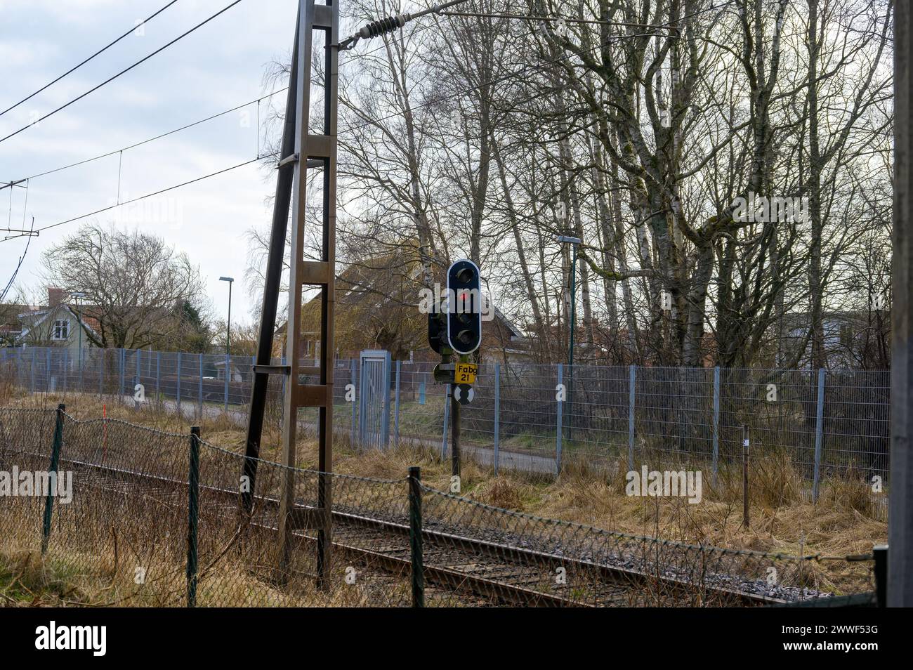 Railroad track with fence on both sides and signal light Stock Photo ...