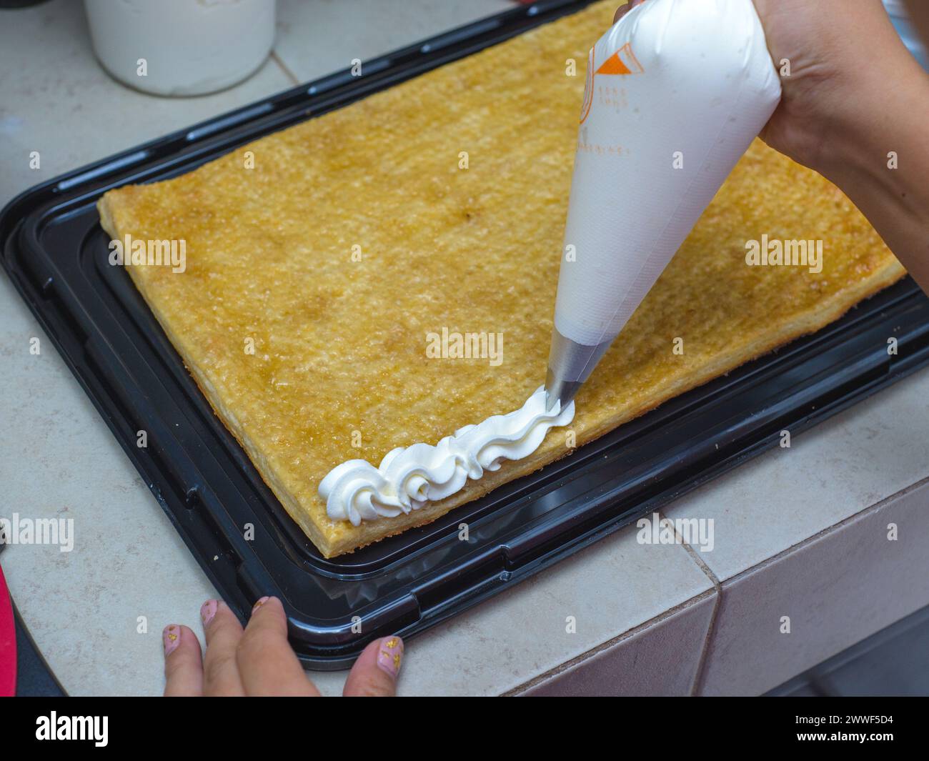 Person decorating a millefeuille cake. Making a cake at home Stock ...