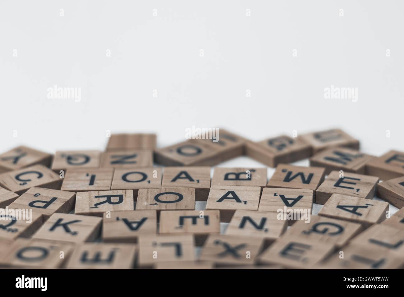Wooden tiles with alphabet letters scattered on white background Stock ...
