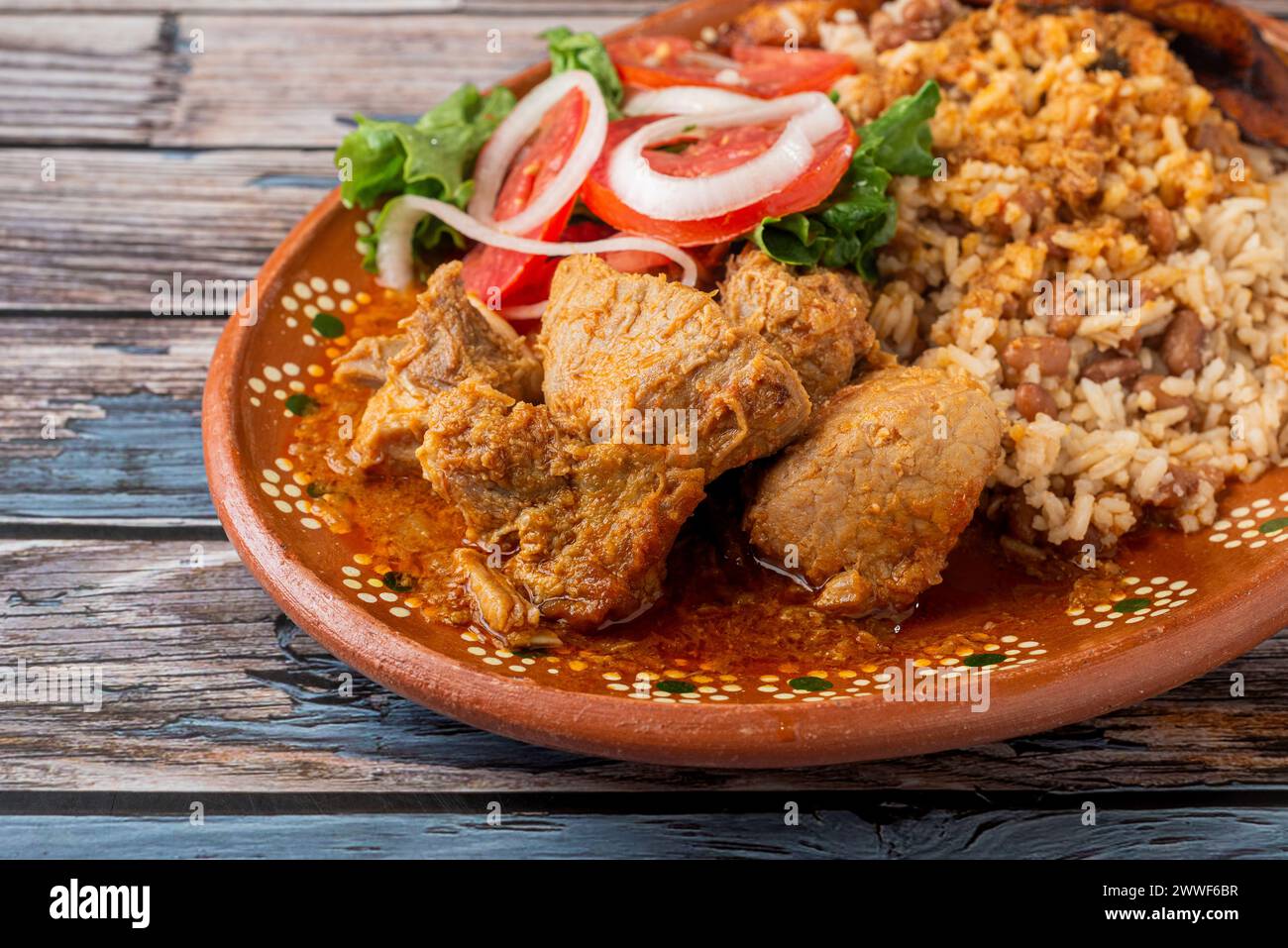 Rice congri with pork fricassee, salad and fried ripe plantain. Typical ...