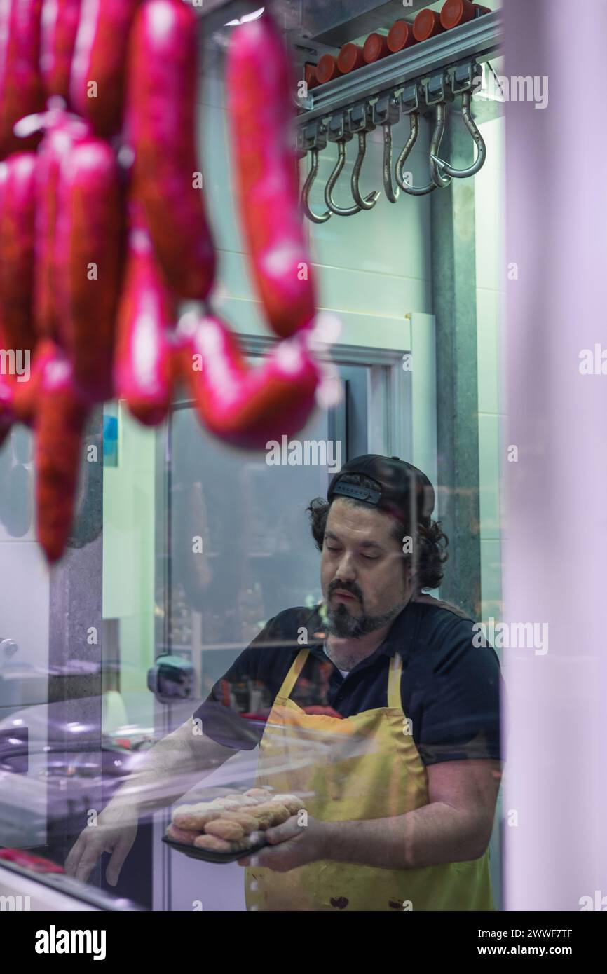 vertical portrait a butcher holding a tray of freshly prepared chicken ...