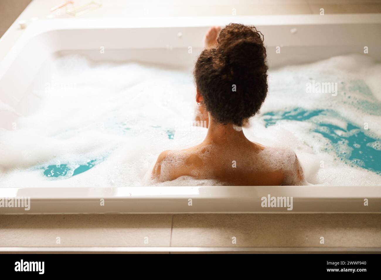 Woman enjoying a bubble bath in a jacuzzi tub filled with water Stock ...