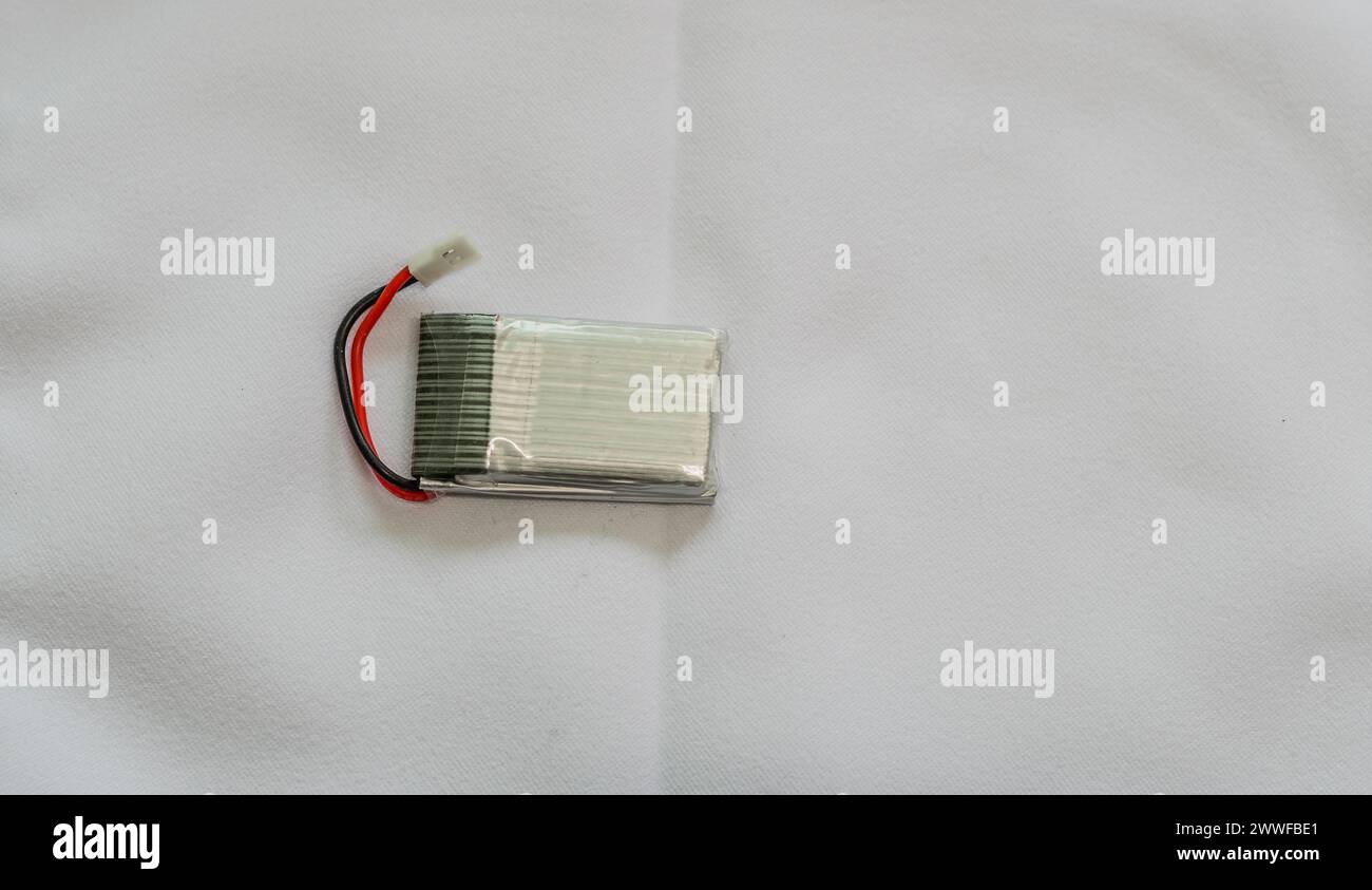 A single lithium polymer battery with red and black wires against a ...
