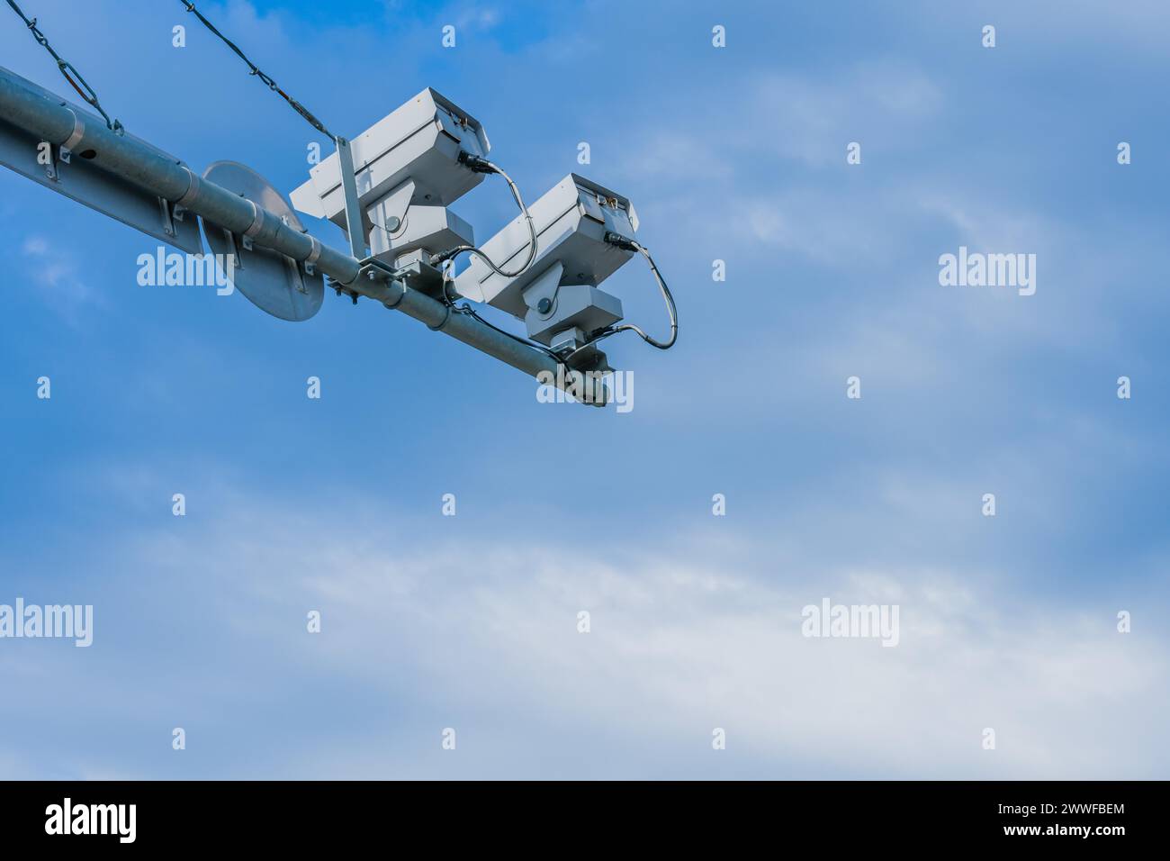 Speed radar cameras mounted on metal pole against blue sky with puffy ...