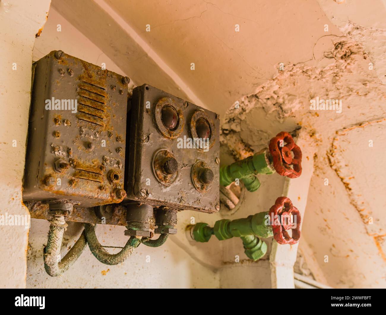 Closeup of rusted electrical circuit boxes and pressure valves with red ...