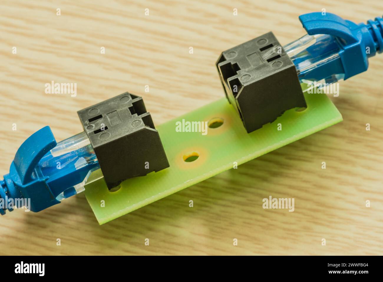 Closeup of homemade ethernet cable connector with blue ethernet cables plugged in each connector ...
