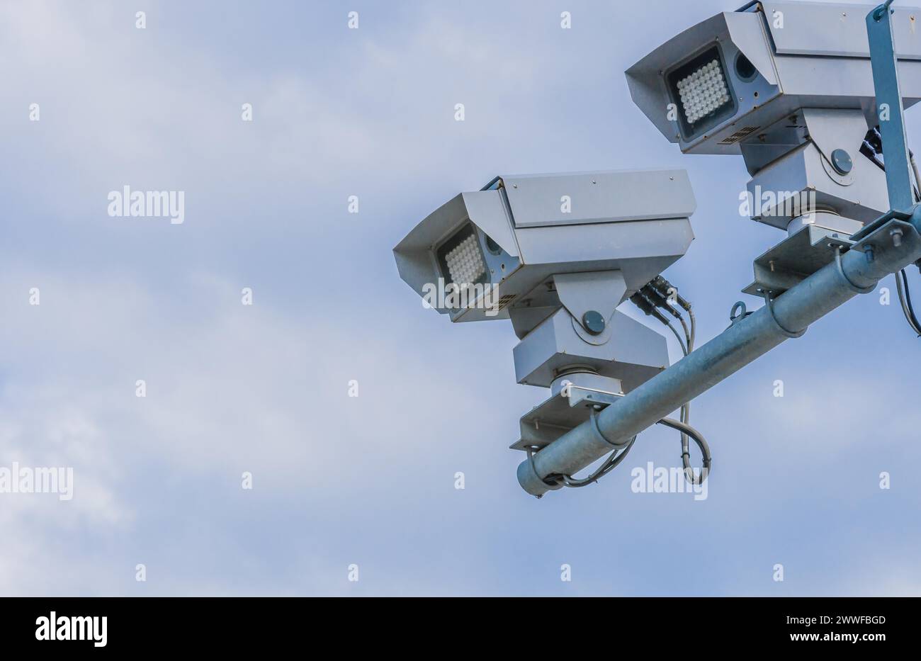 Speed radar cameras mounted on metal pole against blue sky with puffy ...