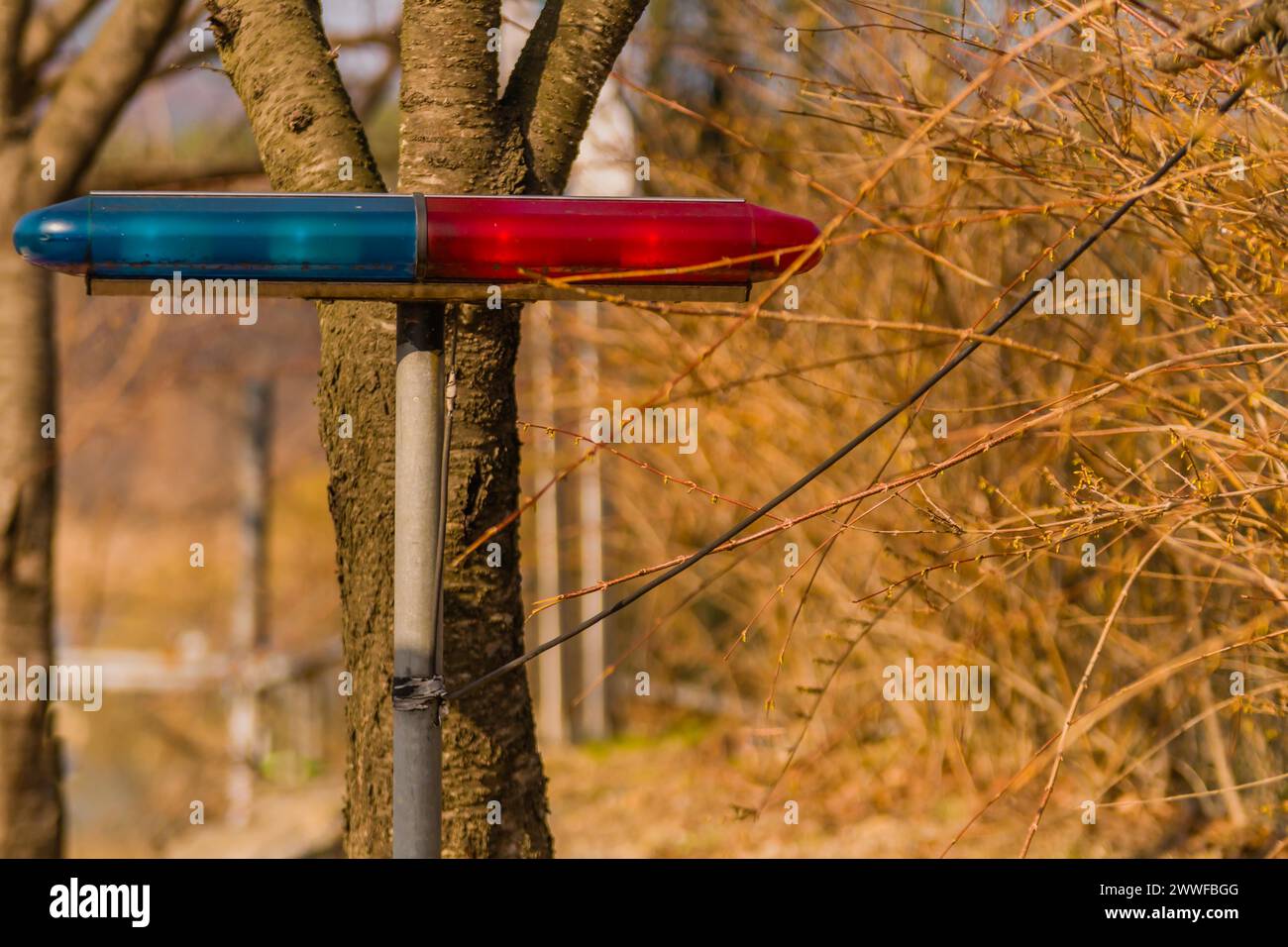 A blue and red emergency light mounted on a pole outdoors, in South ...