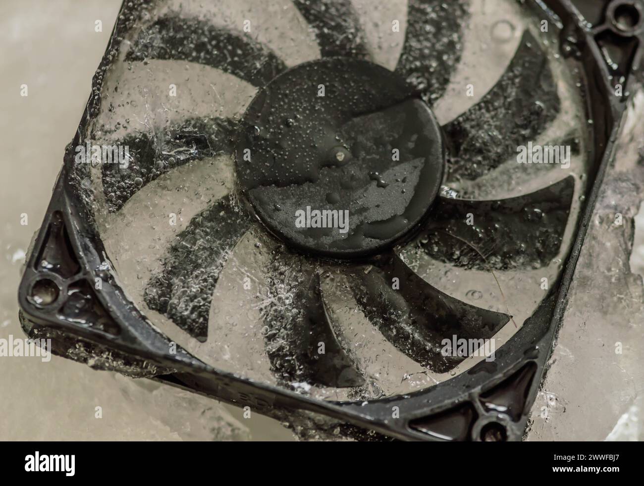 Closeup of computer case fan frozen in block of ice. Concept keep your ...